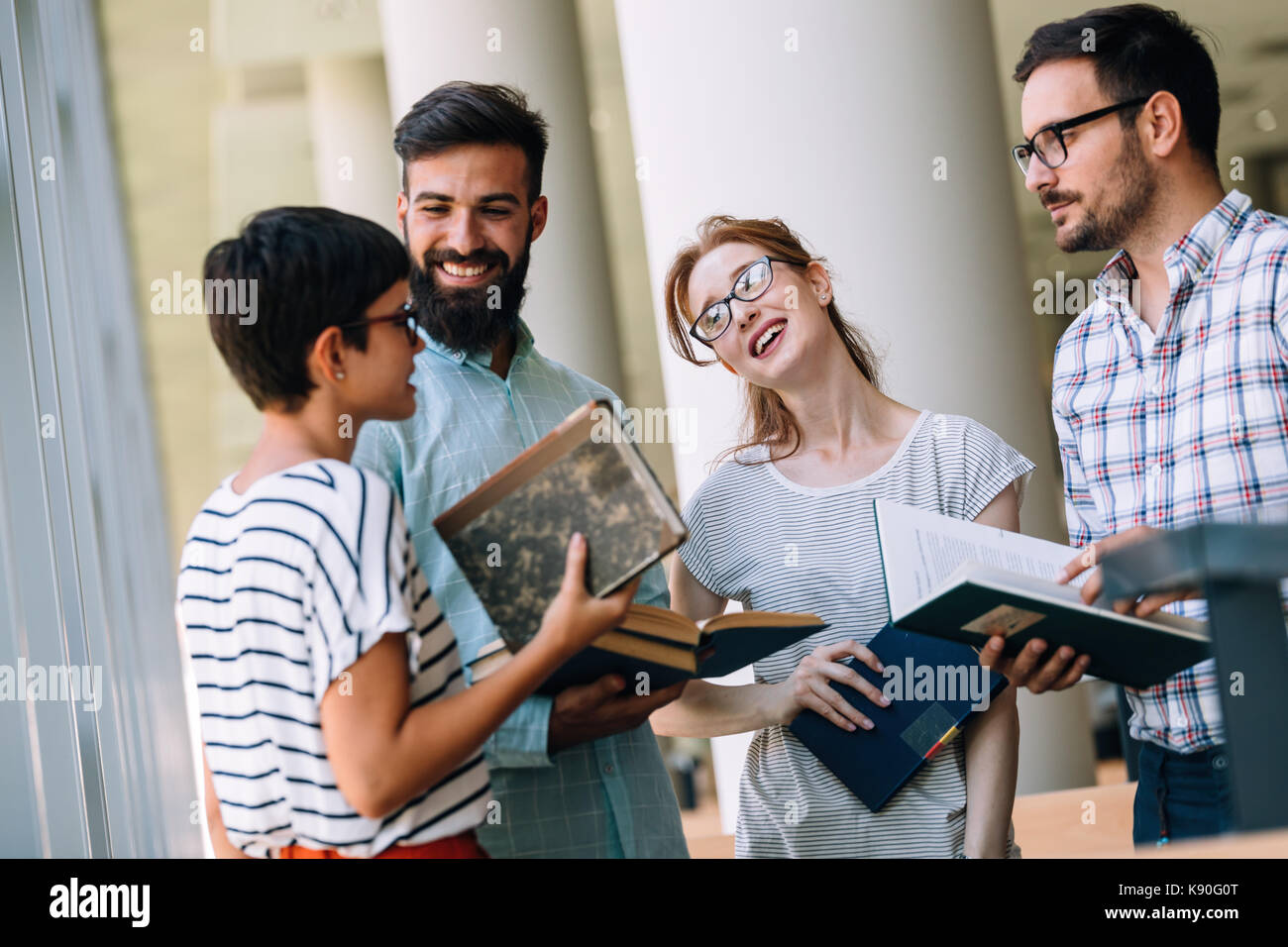 Group of students discussing in university library Stock Photo - Alamy