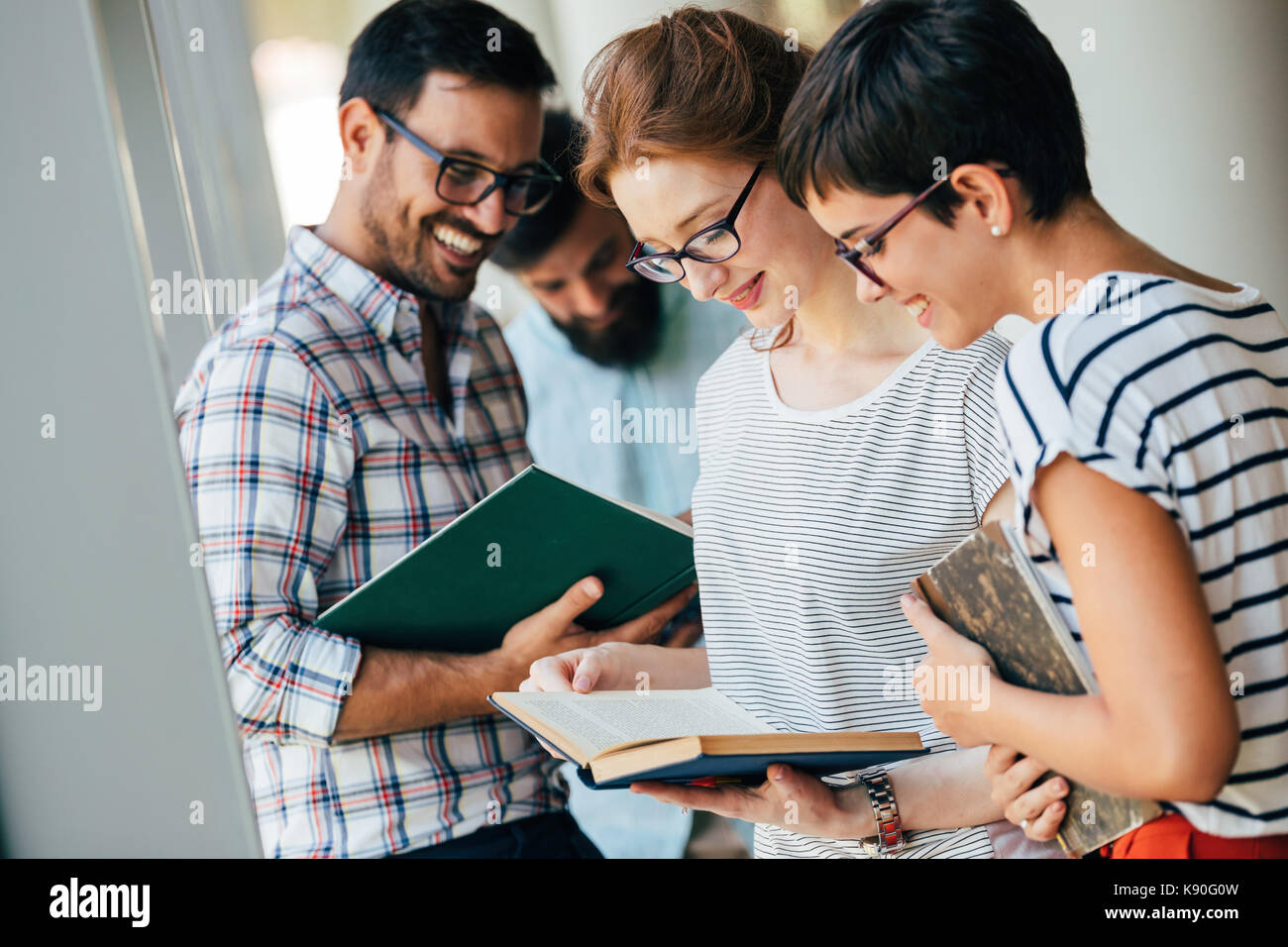 Group of students discussing in university library Stock Photo - Alamy