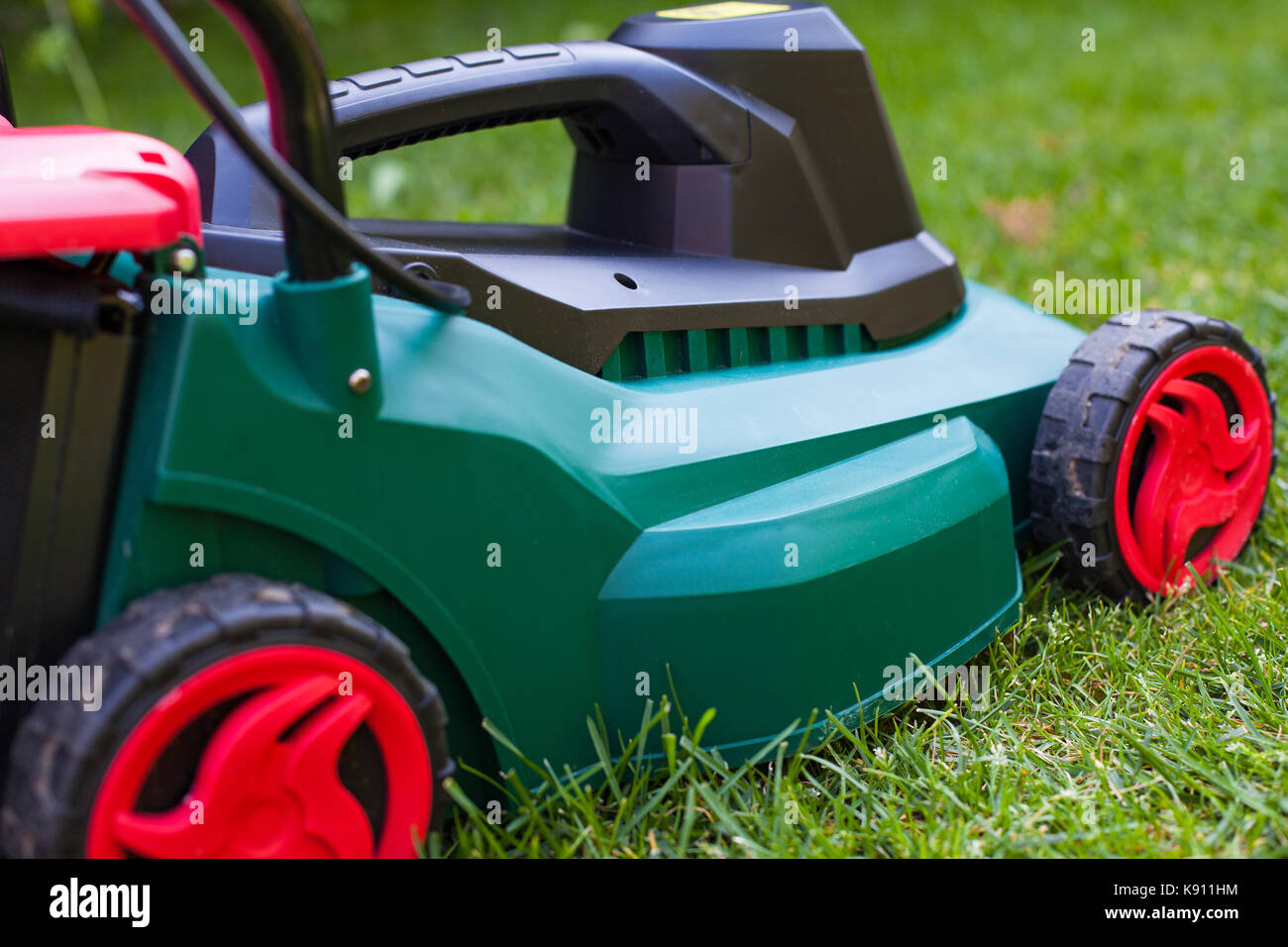 Close up modern lawn mower on the grass in the backyard Stock Photo - Alamy