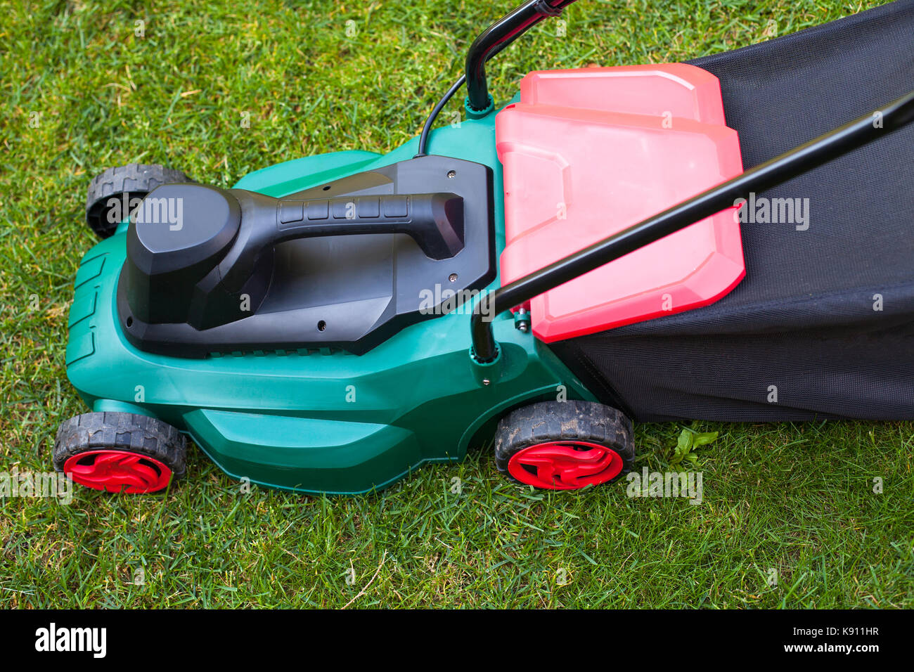 Close up modern lawn mower on the grass in the backyard Stock Photo - Alamy