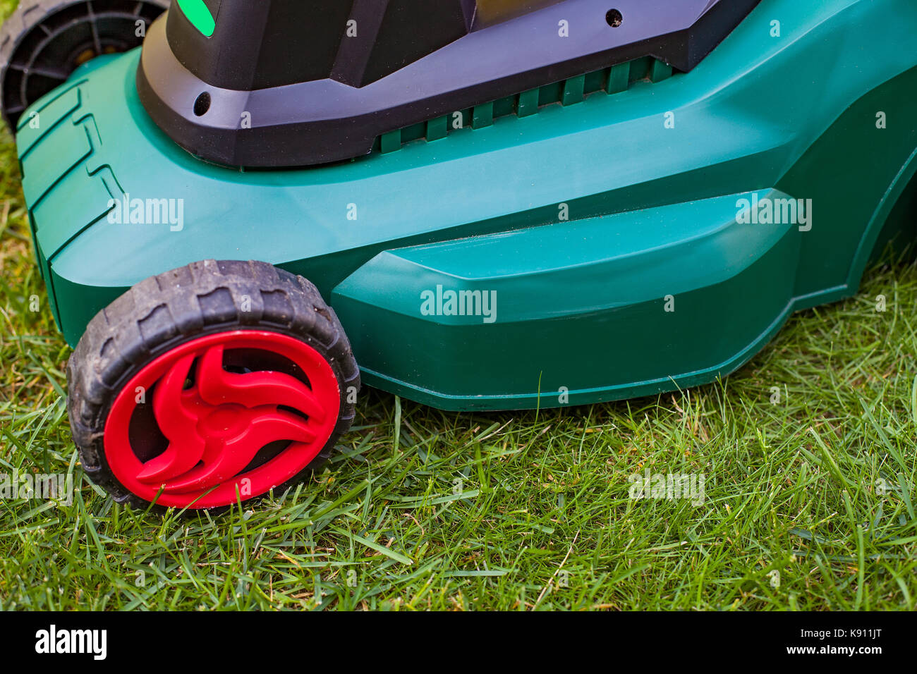 Close up modern lawn mower on the grass in the backyard Stock Photo - Alamy