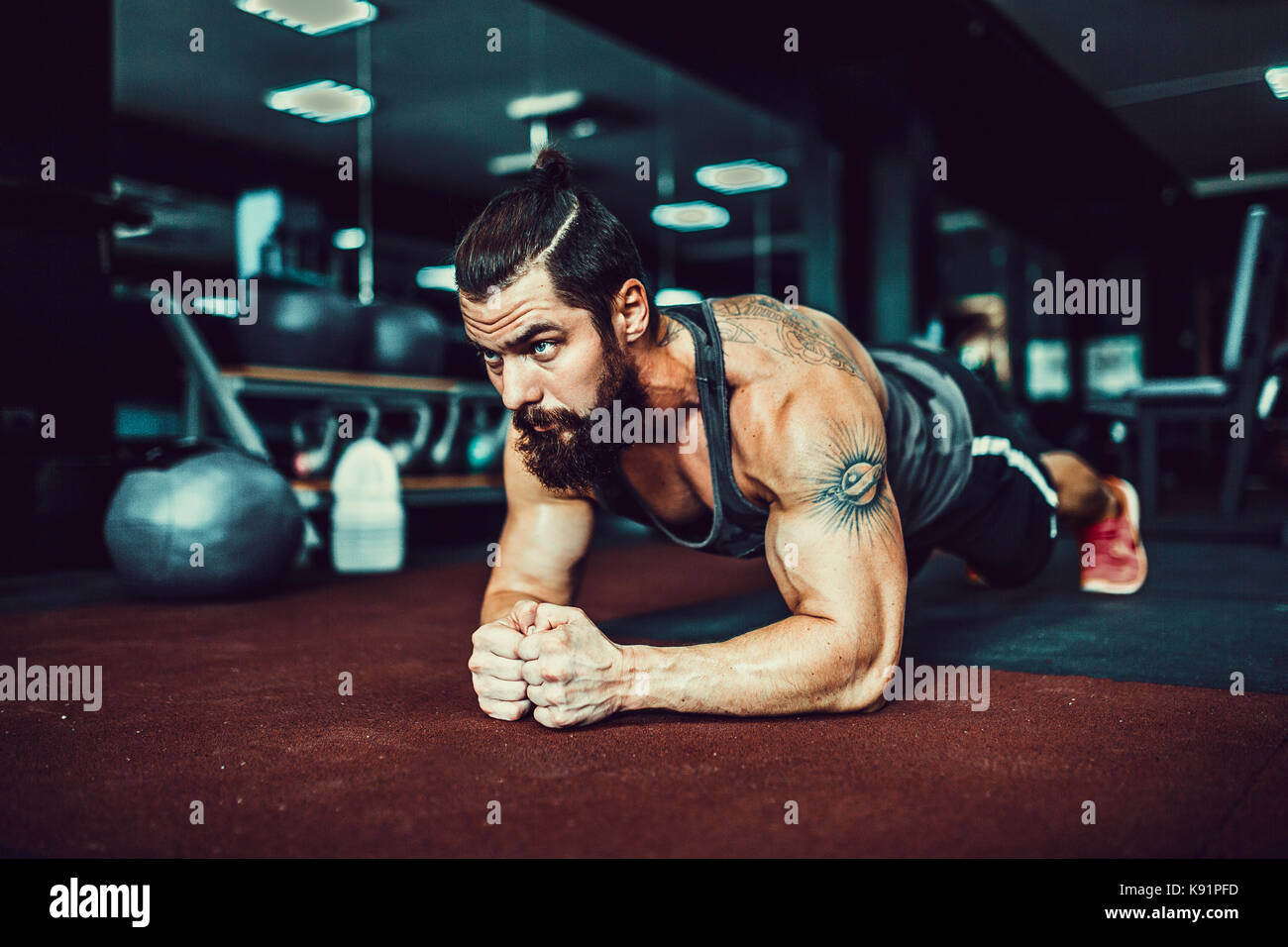 Muscled young man wearing sport wear and doing plank position while ...