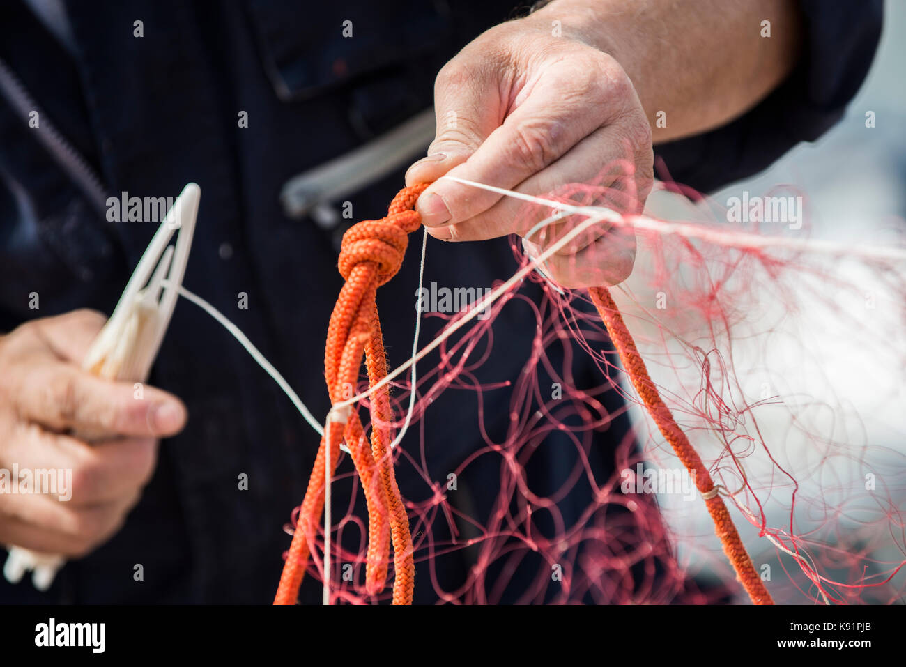 Fisherman in Adriatic sea prepares net for fishing with their hands ...