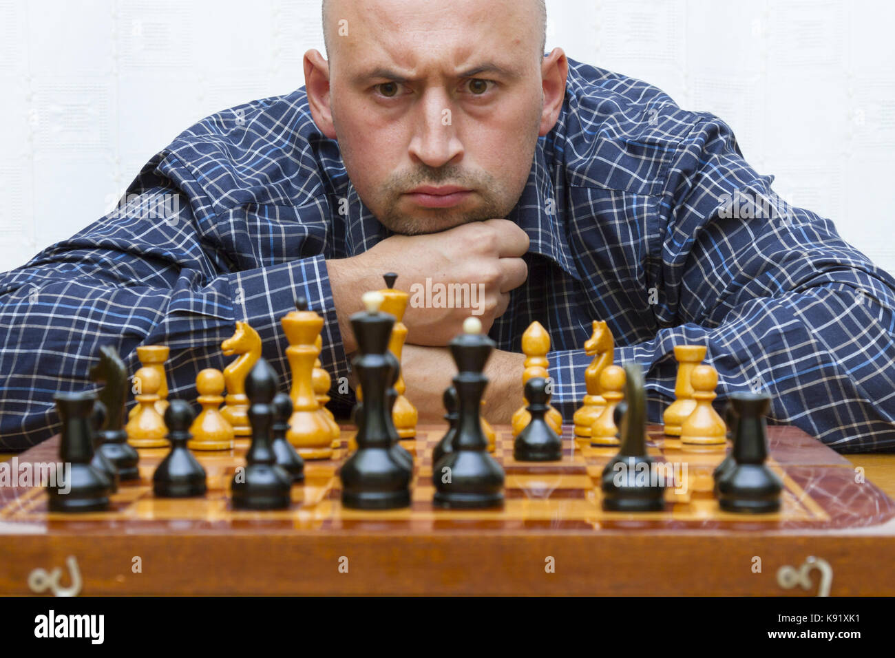 Man playing chess on light background. closeup of young man thinking ...