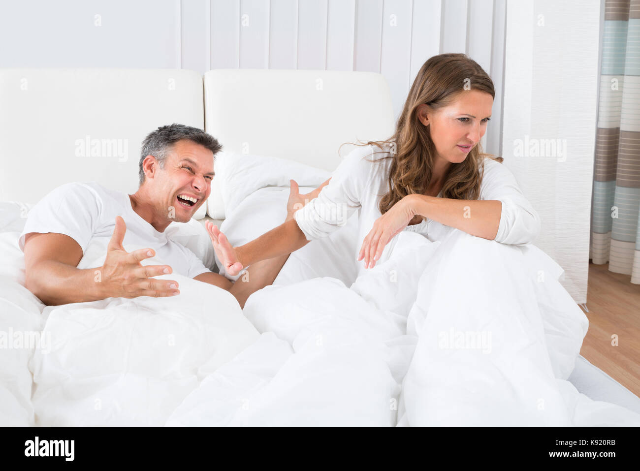 Portrait Of Unhappy Couple Disputing On Bed Stock Photo - Alamy
