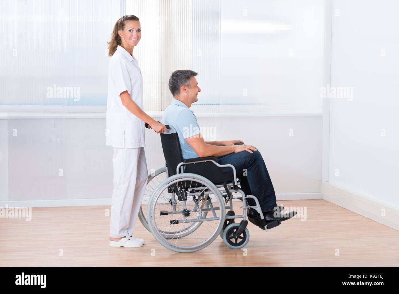 Doctor pushing patient in wheelchair hi-res stock photography and ...