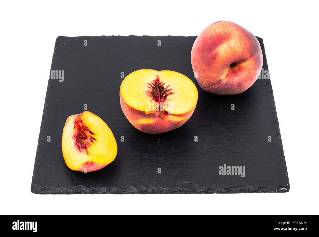Whole and cut ripe peach on black stone. Studio Photo Stock Photo - Alamy