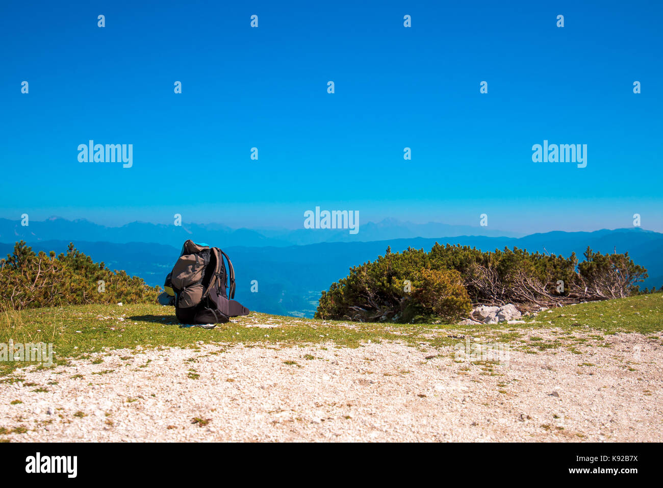 Tourist backpack in mountain landscape on top of the hill with blue sky ...