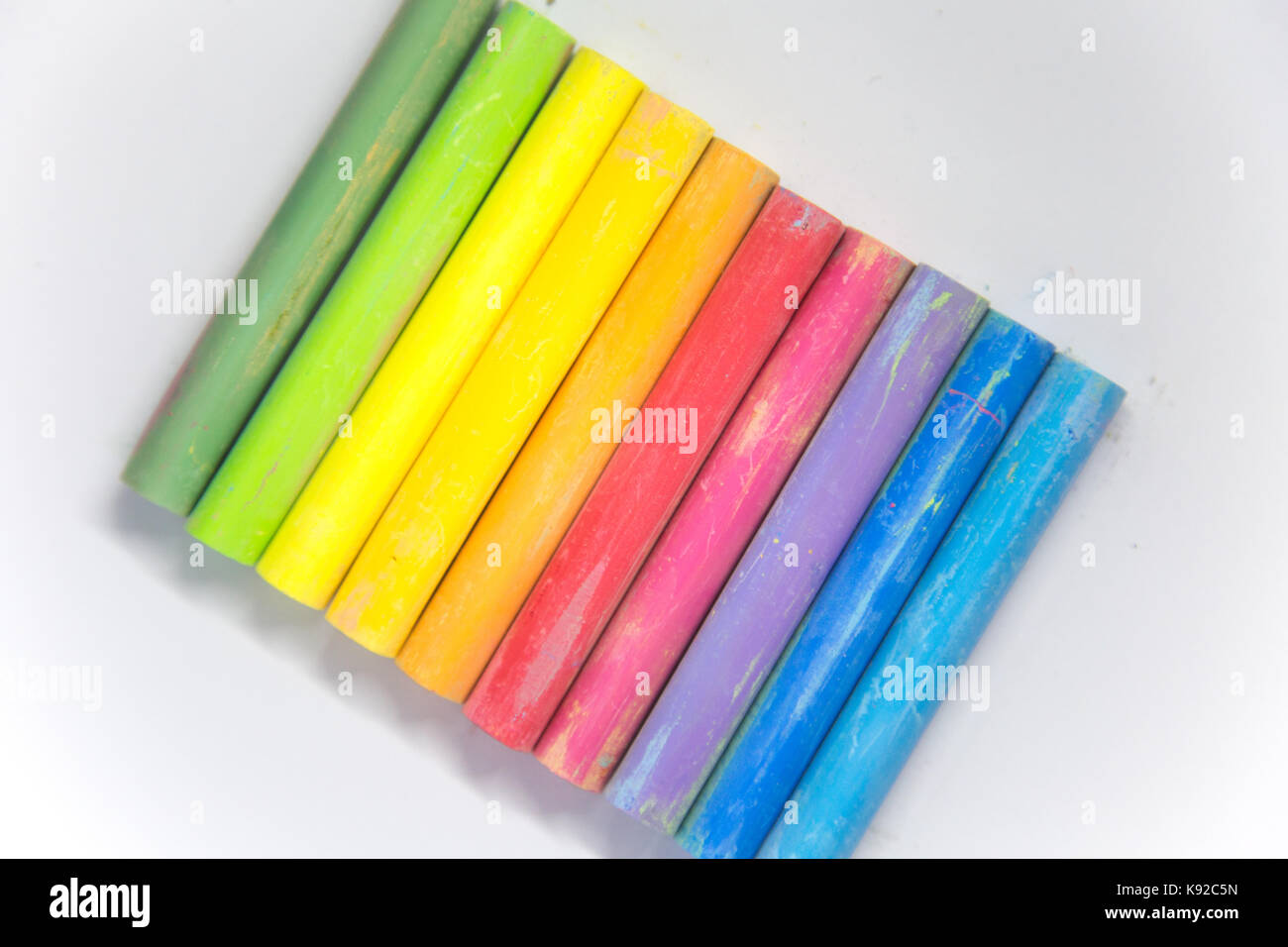 Vivid colorful chalk sticks on a white paper. Beautiful school supplies ...