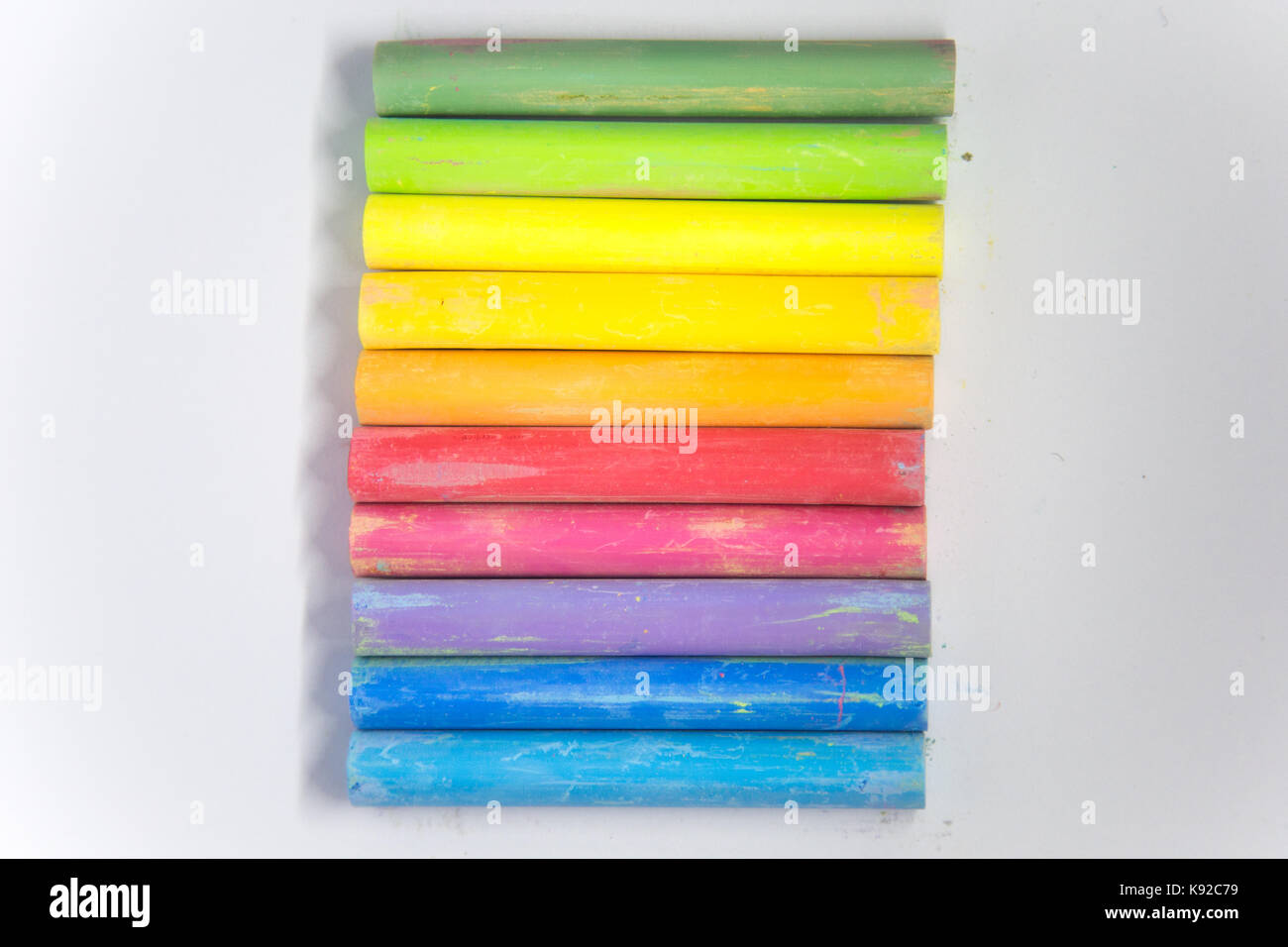 Vivid colorful chalk sticks on a white paper. Beautiful school supplies ...