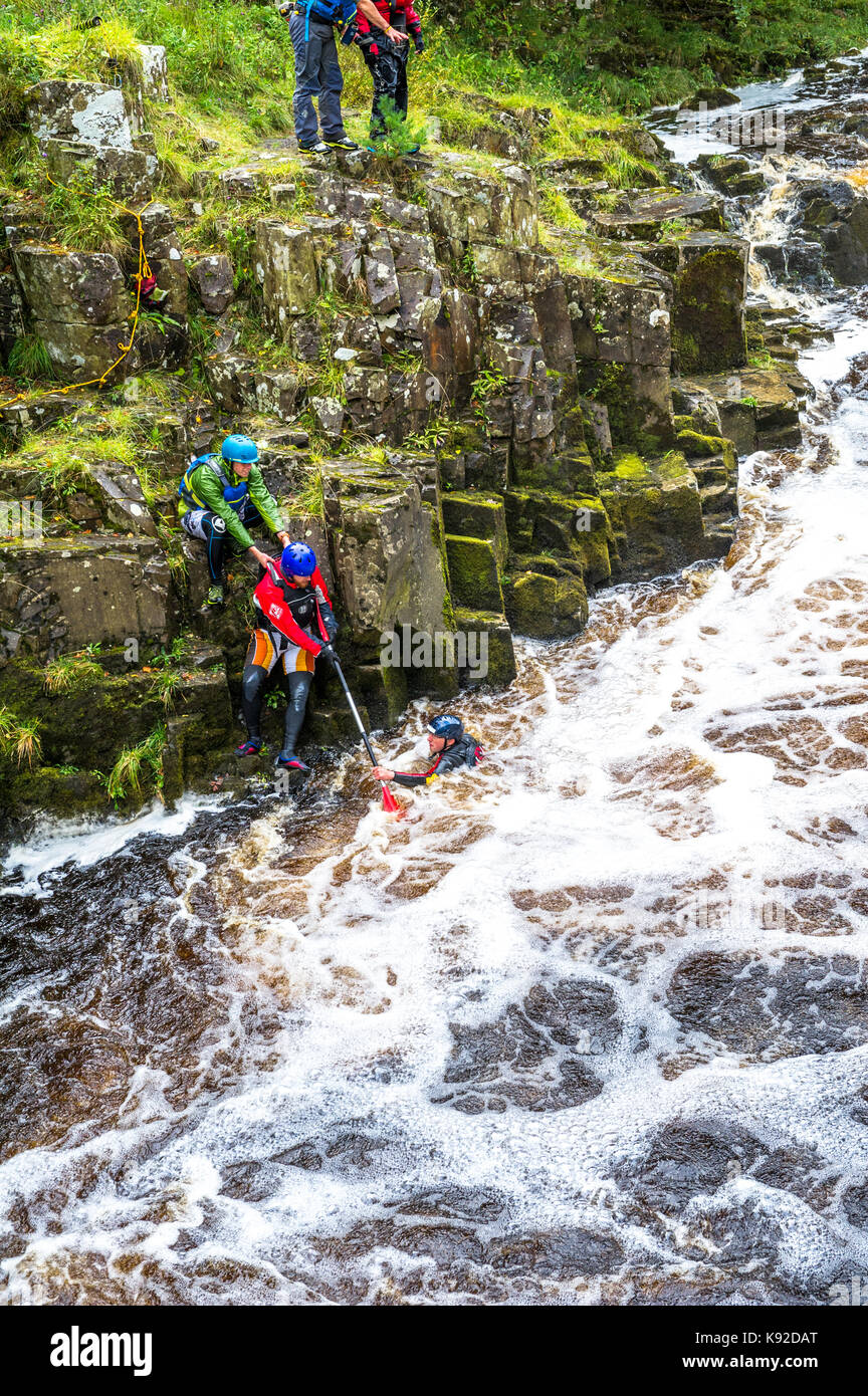 Gorge walking in the River Tees during stormy weather and swollen river ...