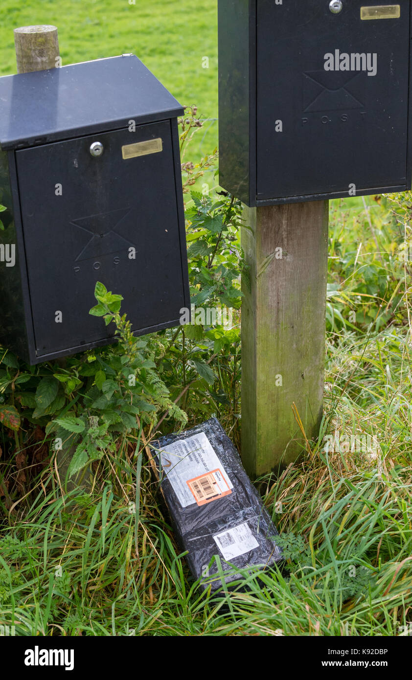 Parcel package left outside in the rain at the foot of a post box Stock ...
