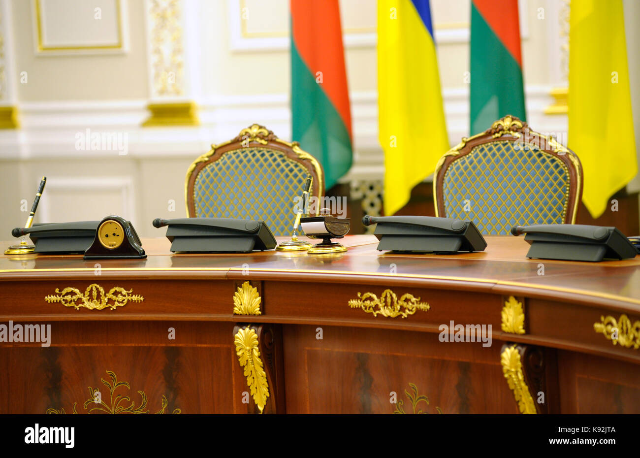 A conference room in a Public institution. Flags, desk and stationary ...