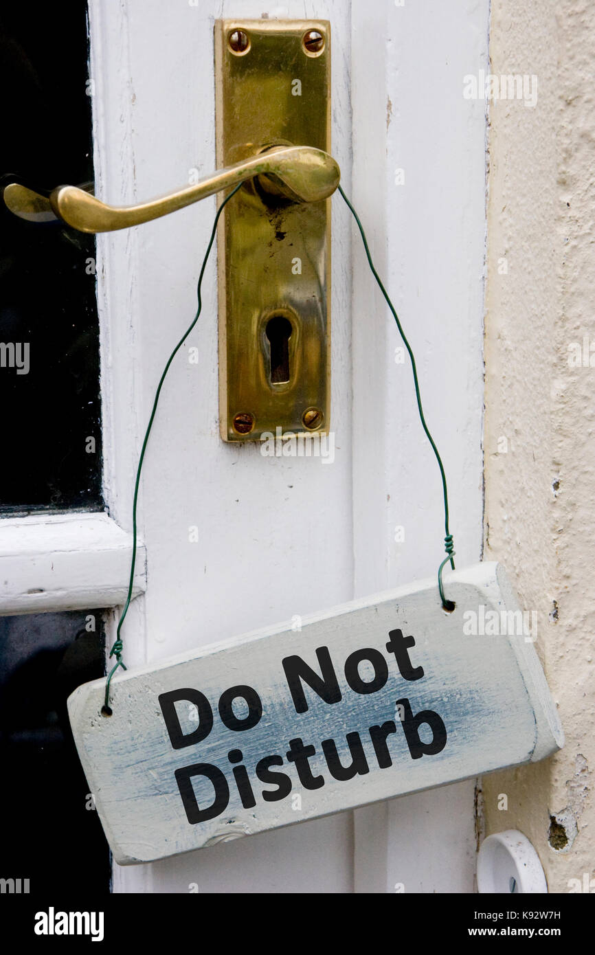 Wooden Do Not Disturb sign hanging from a door handle Stock Photo - Alamy
