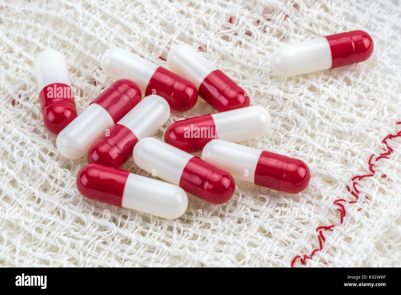 Some white and red pills wrapped in gauze Stock Photo - Alamy