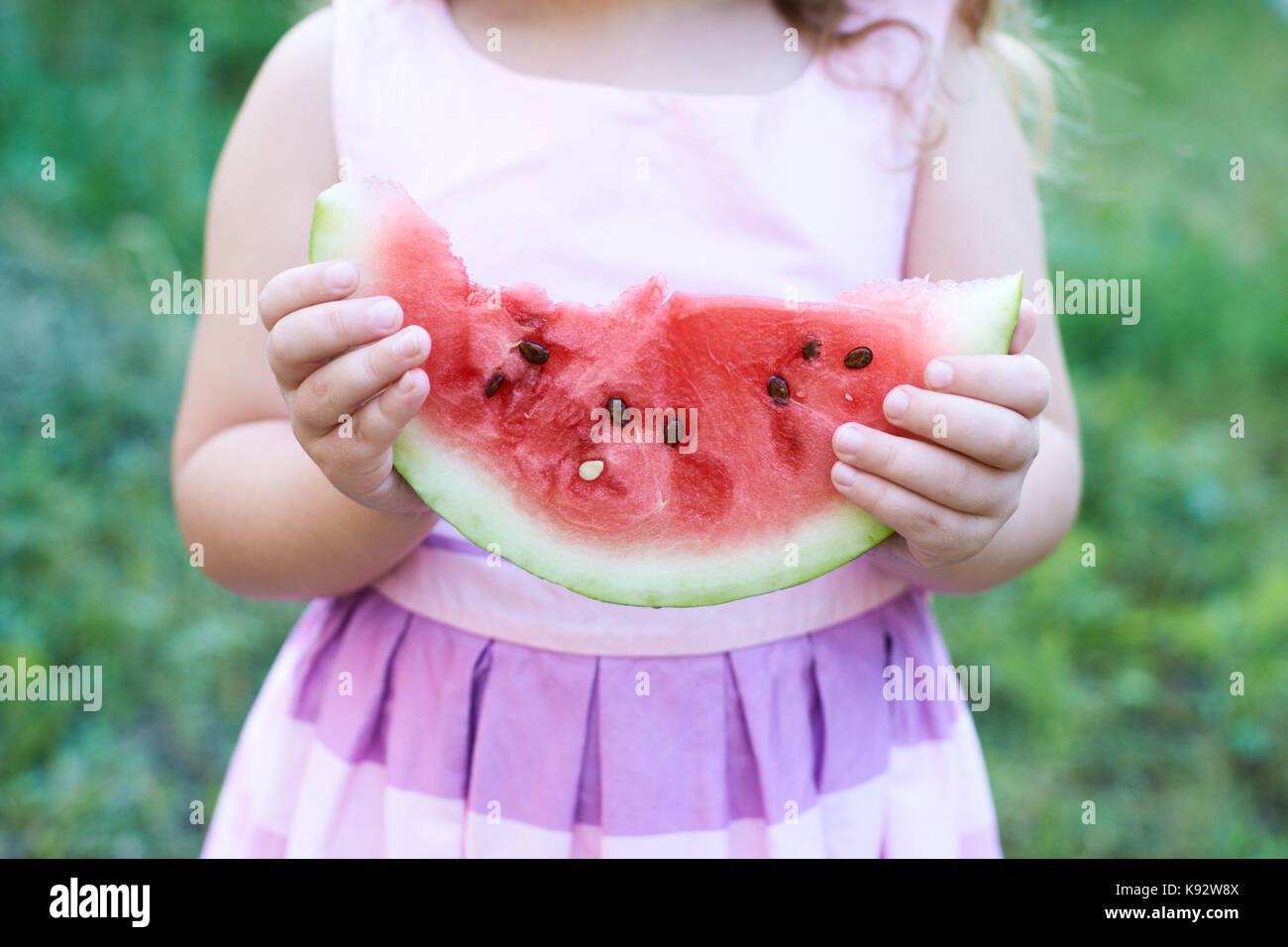 Little girl holding watermelon piece Stock Photo - Alamy