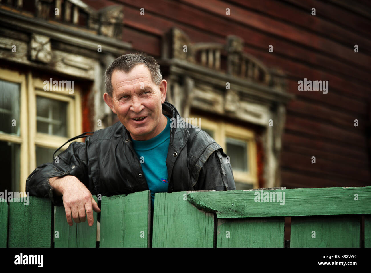 Russian old man look out fence. Old house Stock Photo - Alamy