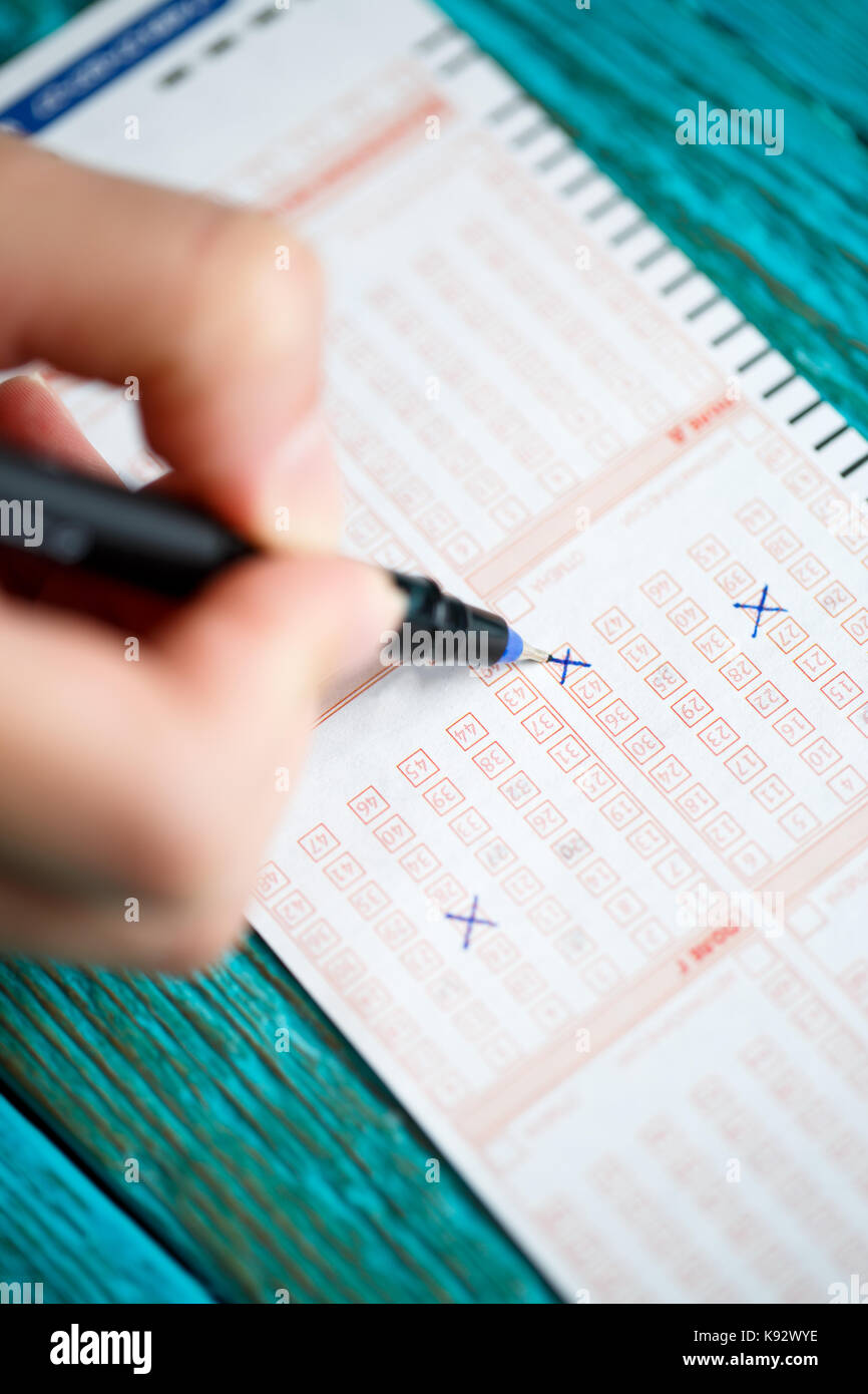 Photo on top of hand with pen, lottery ticket Stock Photo - Alamy