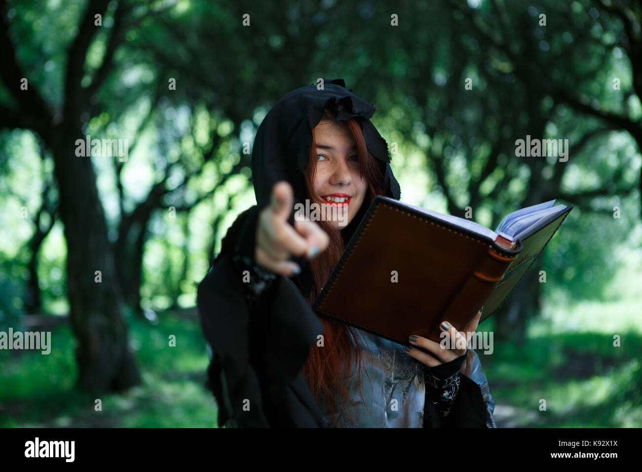 Smiling witch in magical forest Stock Photo - Alamy