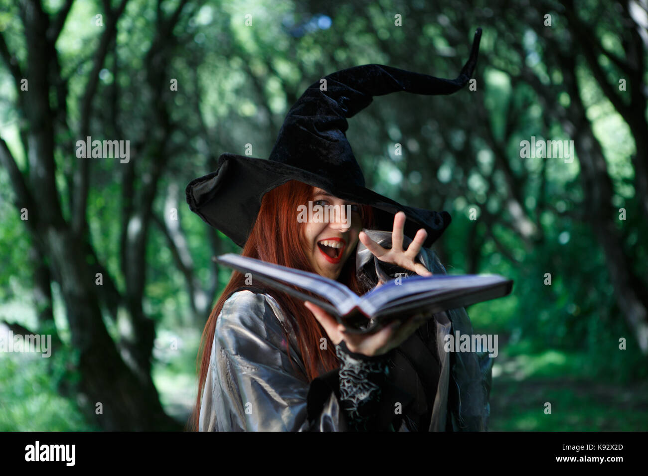 Photo of young witch with book Stock Photo - Alamy