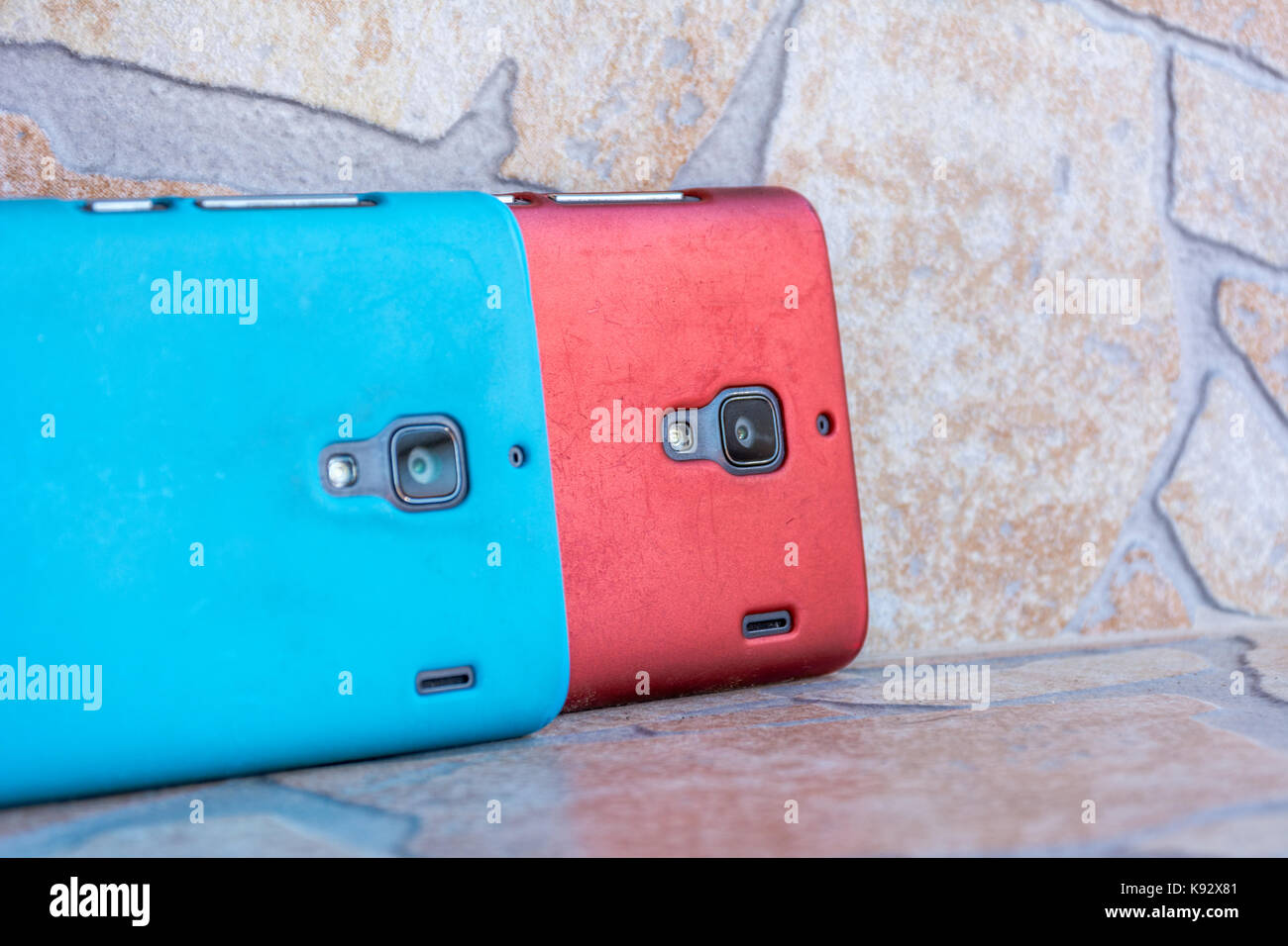 Two smart phones red and blue color horizontal Stock Photo - Alamy