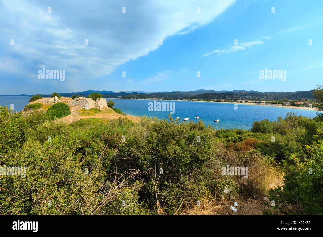 Summer sea coast landscape with old ruins of Ancient City Toroni fort ...