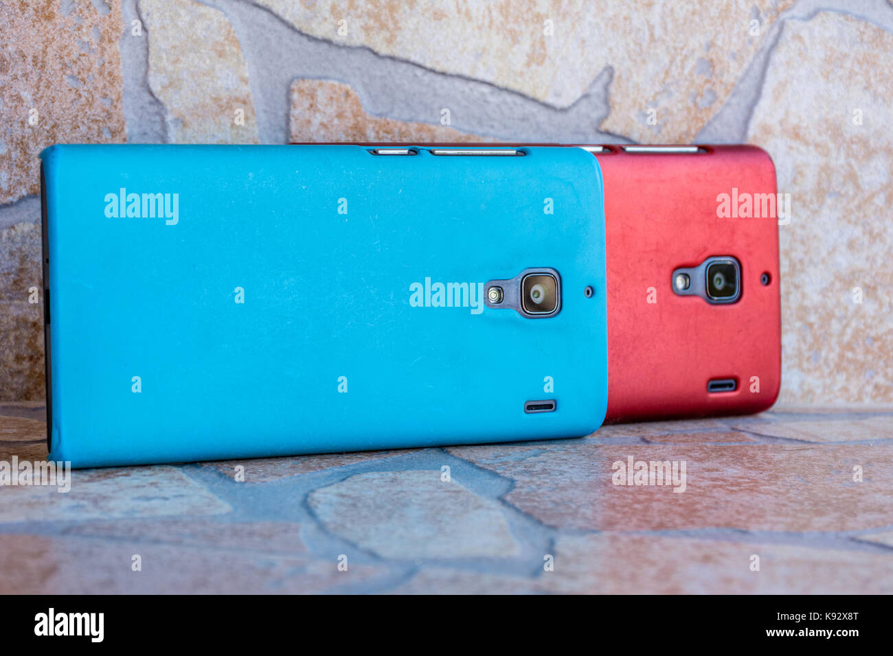 Two smart-phones on ceramic tiles Stock Photo - Alamy
