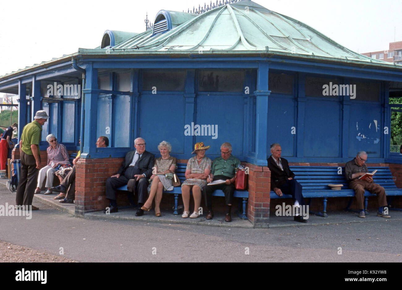 Elderly people at a seaside resort seated in a pavilion enjoying the ...