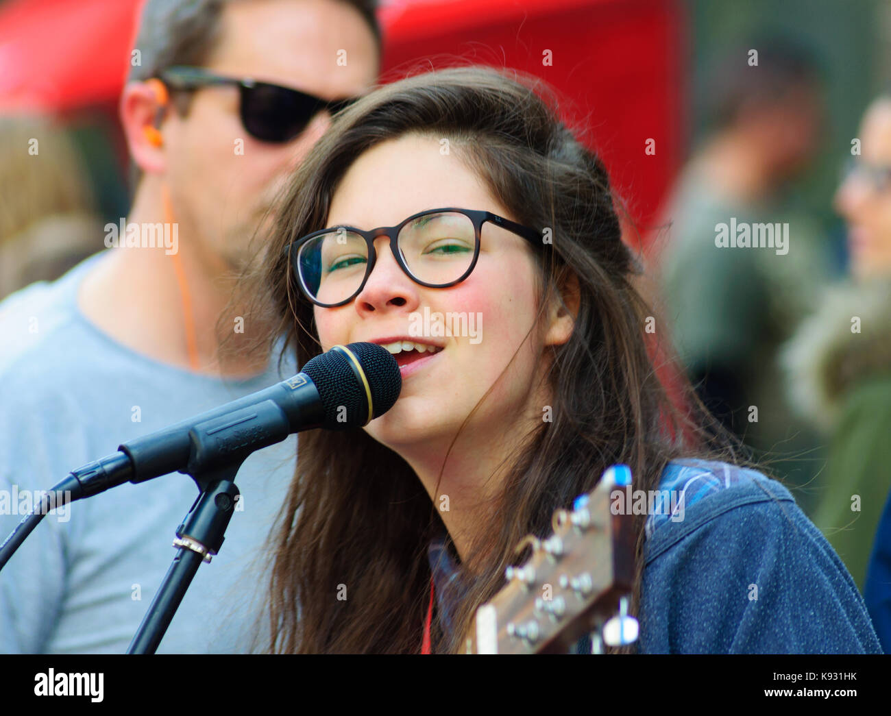Female musician singing and playing the guitar on the Royal Mile during ...
