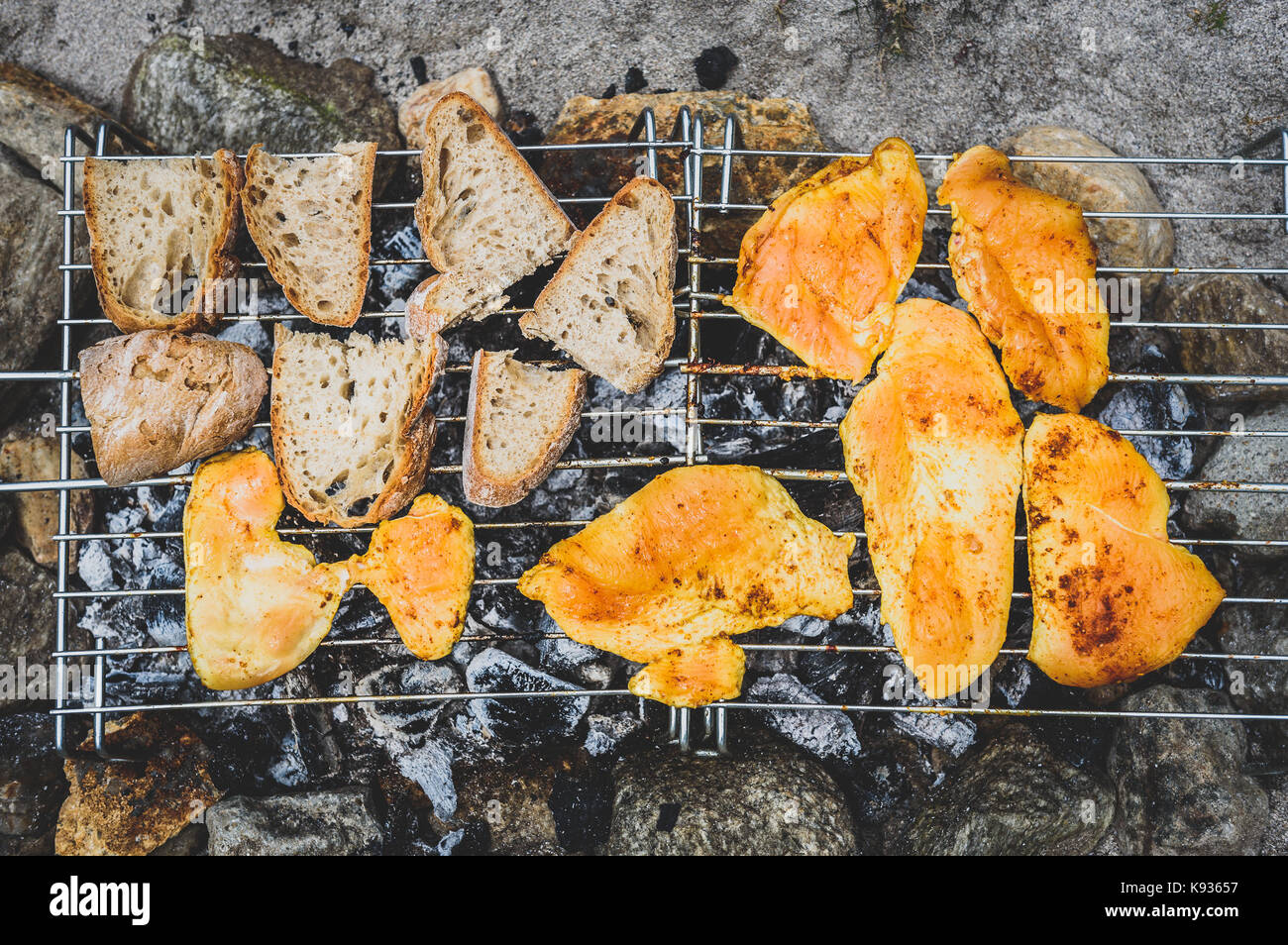 Chicken and bread on homemade improvised BBQ barbecue grill. Making ...