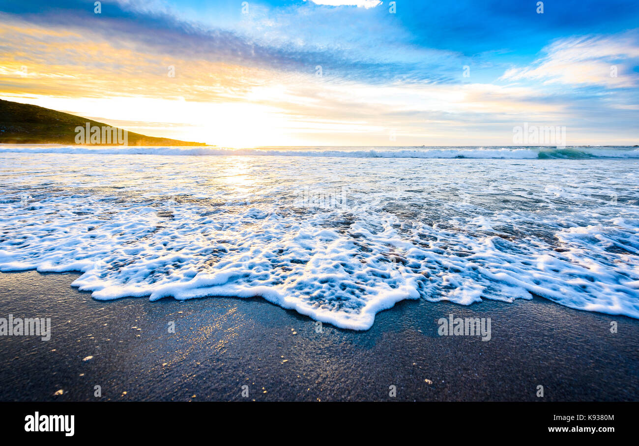 Small ocean sea waves on sandy beach with sunrise sunset. Background ...