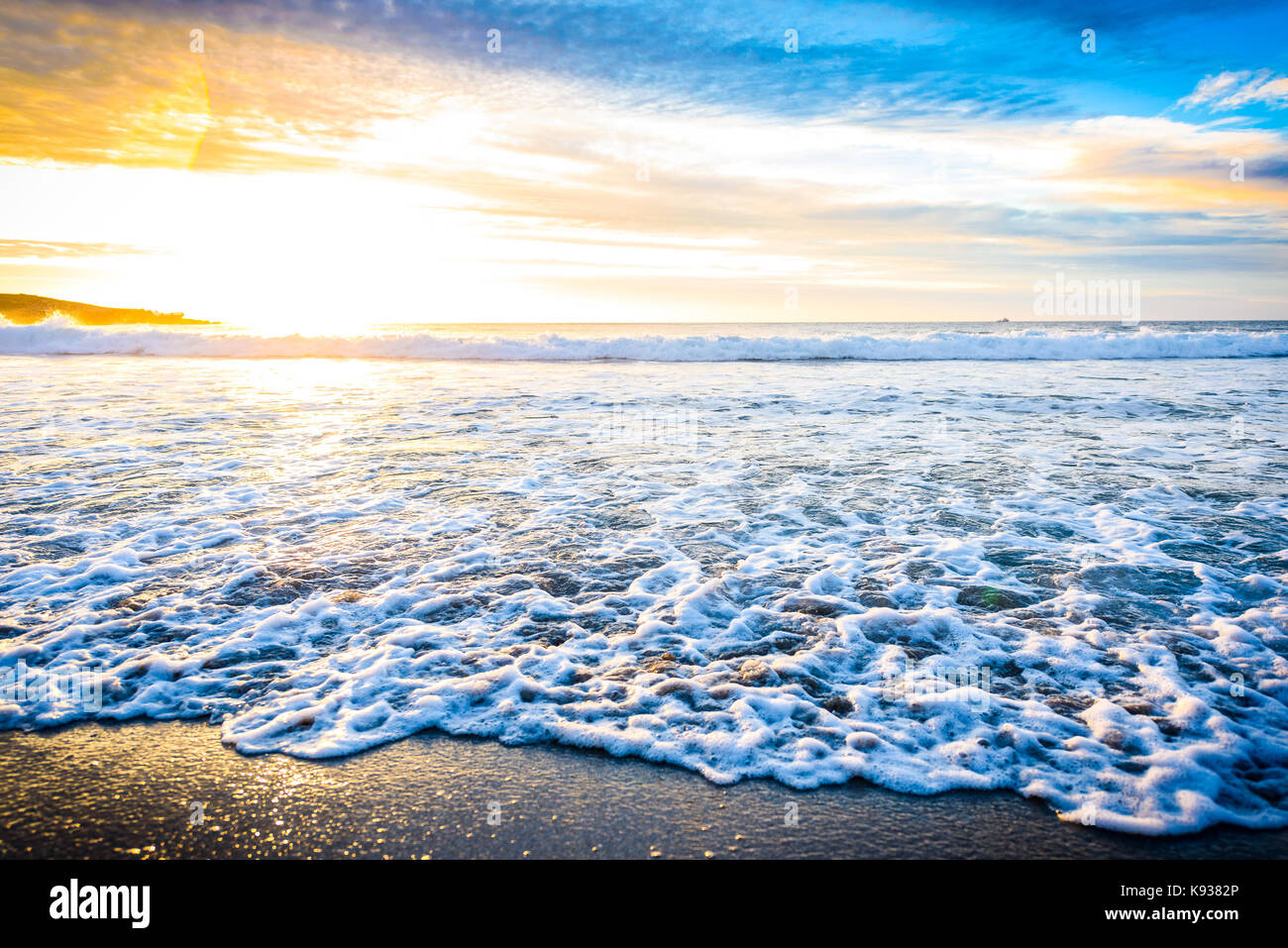 Small ocean sea waves on sandy beach with sunrise sunset. Background ...