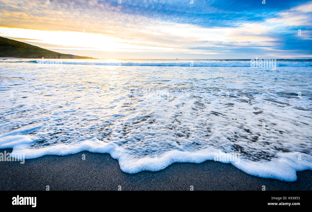 Small ocean sea waves on sandy beach with sunrise sunset. Background ...