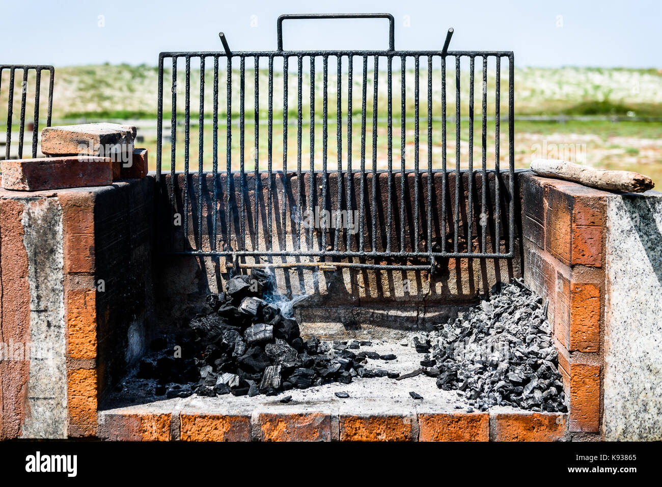 Coal in BBQ barbecue grill on sandy beach on vacation. Making a coal or ...