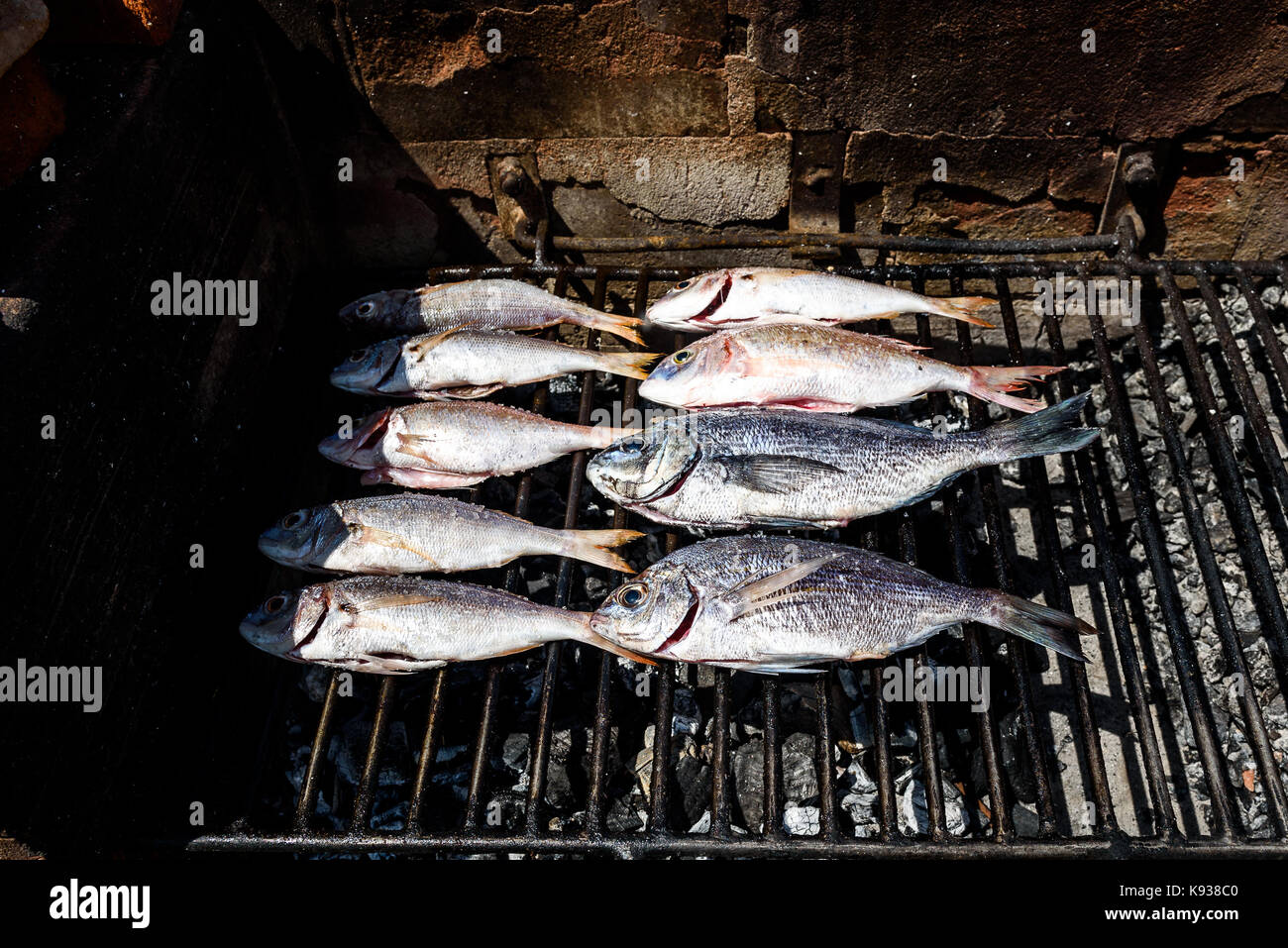 Making fish on a bbq barbecue grill over hot coal. Preparing and ...
