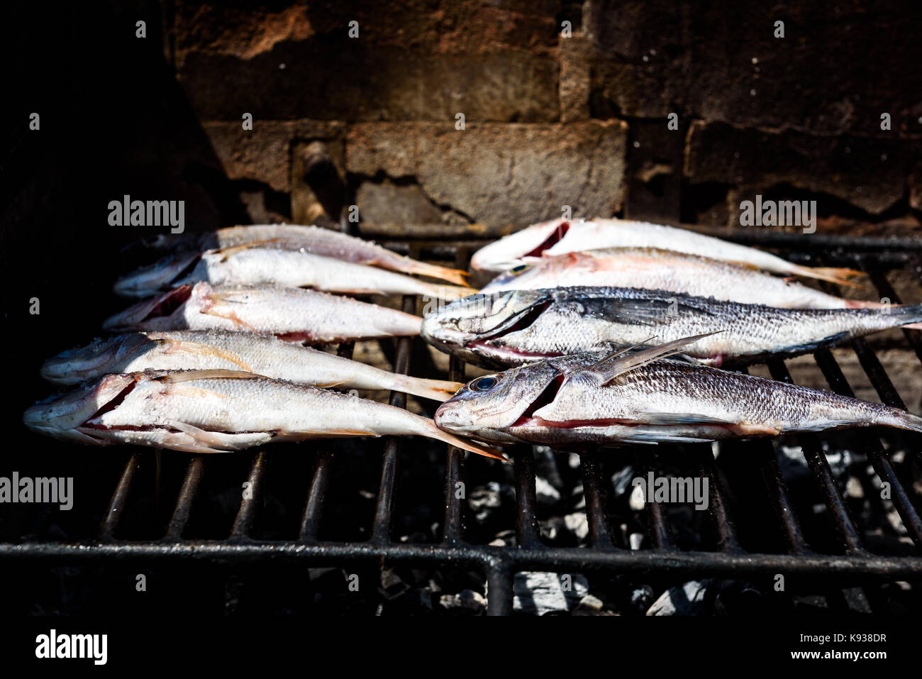 Making fish on a bbq barbecue grill over hot coal. Preparing and ...