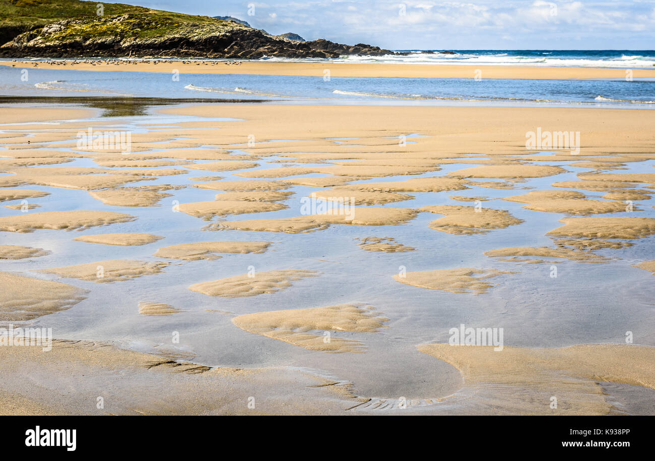 Puddles of water on sandy beach after a tide. Small pools of water in ...