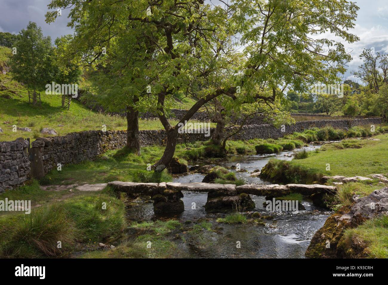 Old stone footbridge crossing the Malham Beck at Malham Cove, Yorkshire ...