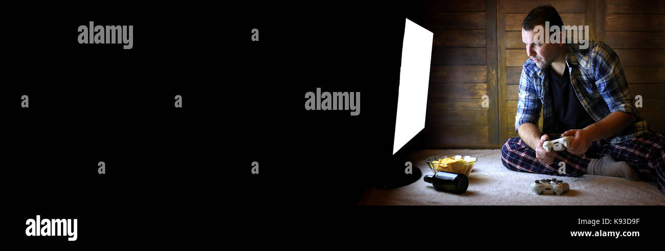 man playing on a console on the joystick before the big TV scree Stock ...