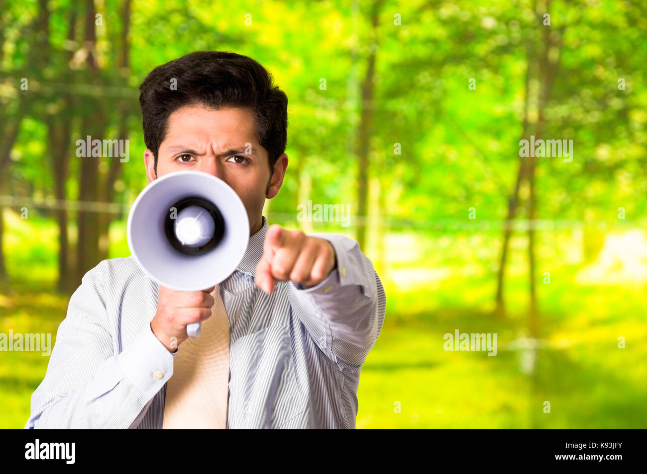 Portrait of a handsome man shouting with a megaphone while he is ...