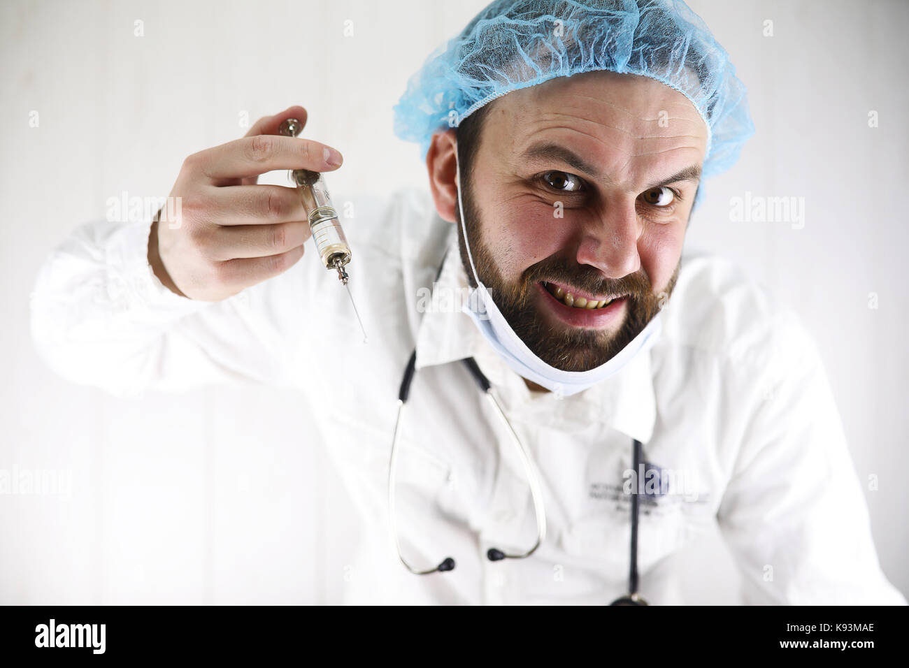 Crazy bearded doctor in a white coat and old syringe Stock Photo - Alamy