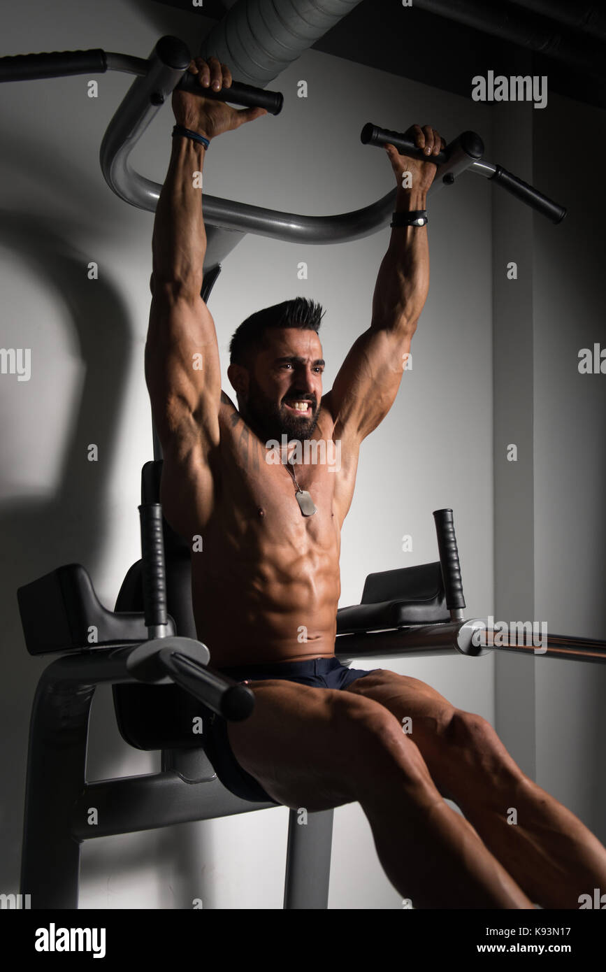 Young Man Performing Hanging Leg Raises Exercise - One Of The Most ...