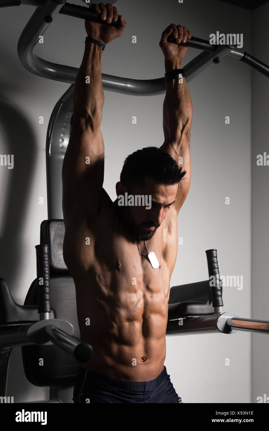 Young Man Performing Hanging Leg Raises Exercise - One Of The Most ...