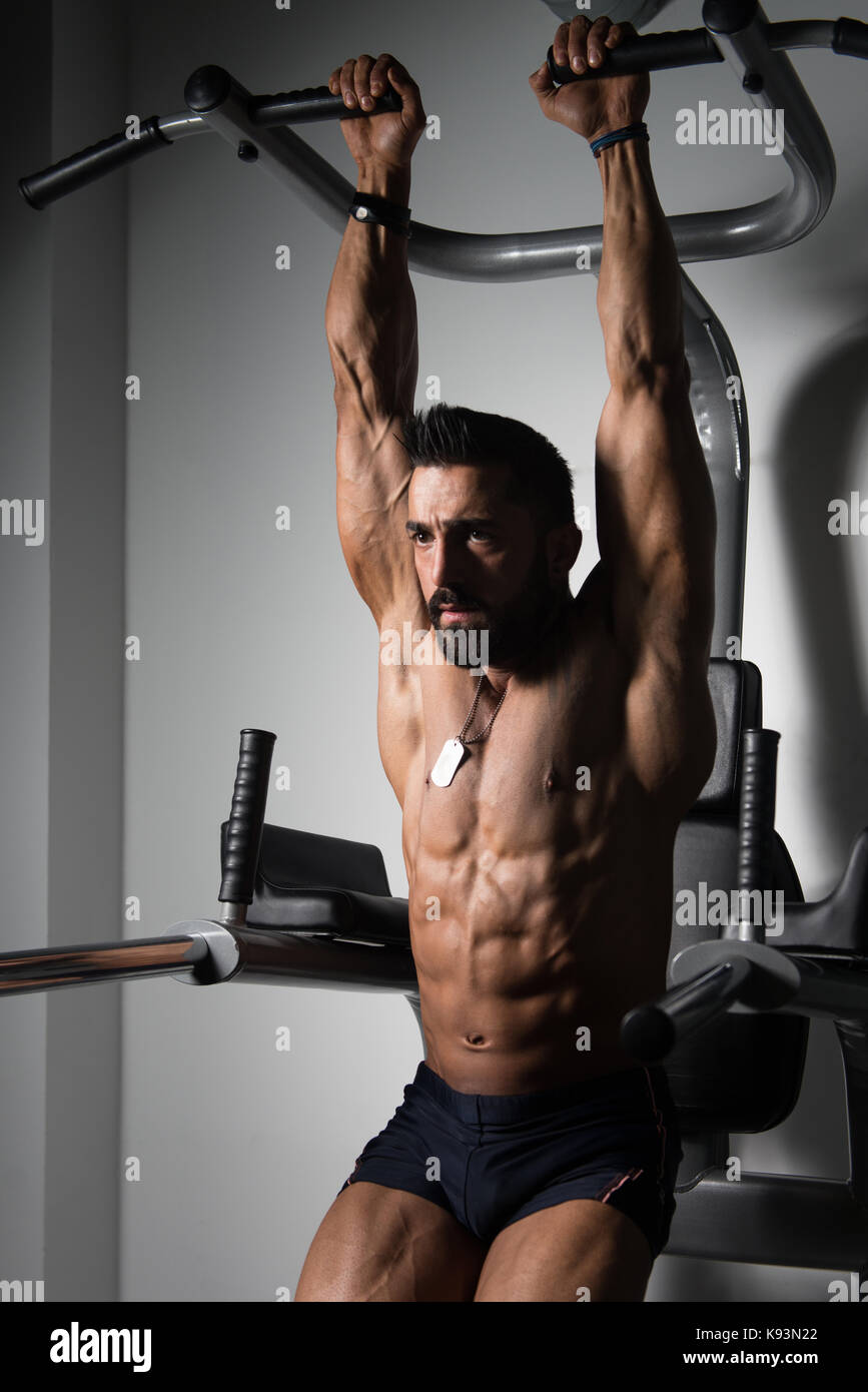Young Man Performing Hanging Leg Raises Exercise - One Of The Most ...