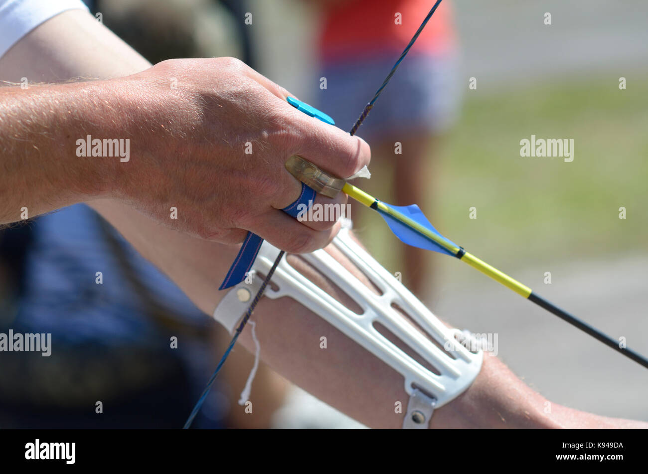 An archer’s hand pulling the string back of a bow Stock Photo - Alamy