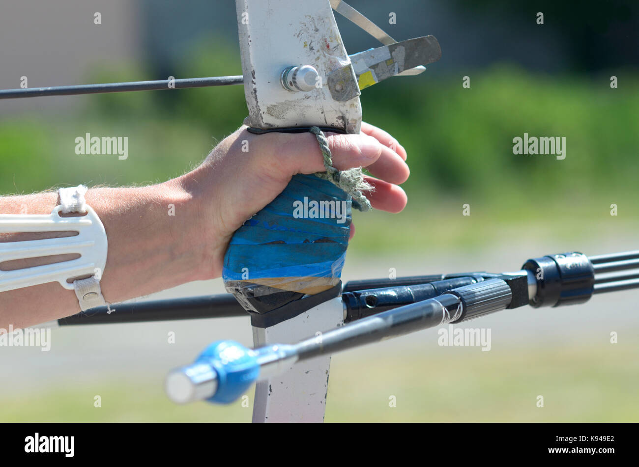 An archer’s hand pulling the string back of a bow Stock Photo - Alamy