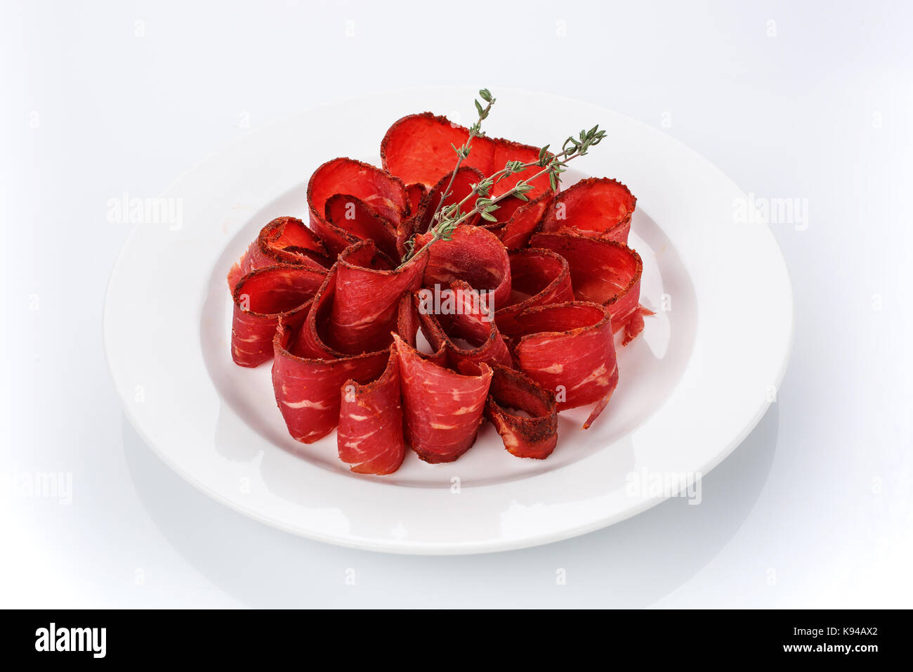 Basturma on plate isolated on white background Stock Photo - Alamy