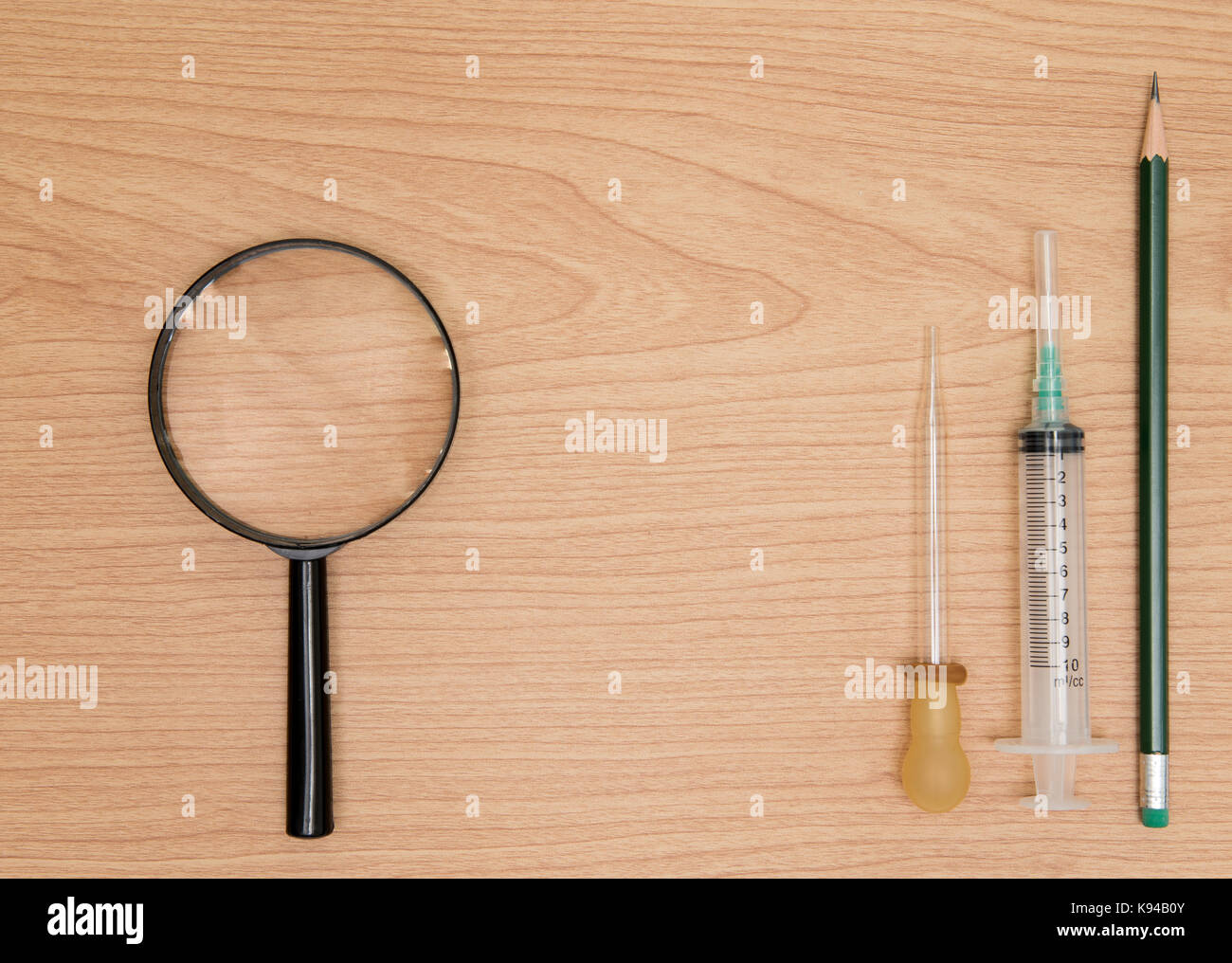 STEM concept. Magnifying glass, dropper, Syringe, pencil on the wood ...