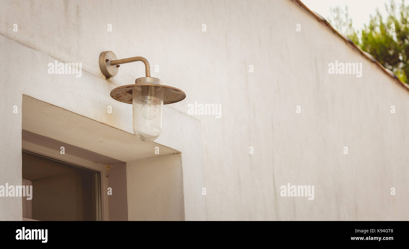 close up modern metal hanging lamp in front of a window on a wall Stock ...
