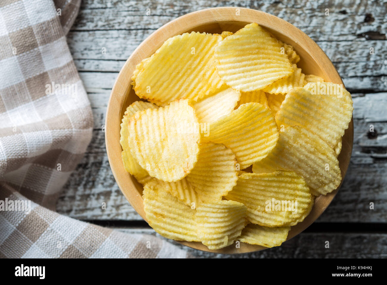 Crispy potato chips in wooden bowl. Salted potato chips. Top view Stock ...